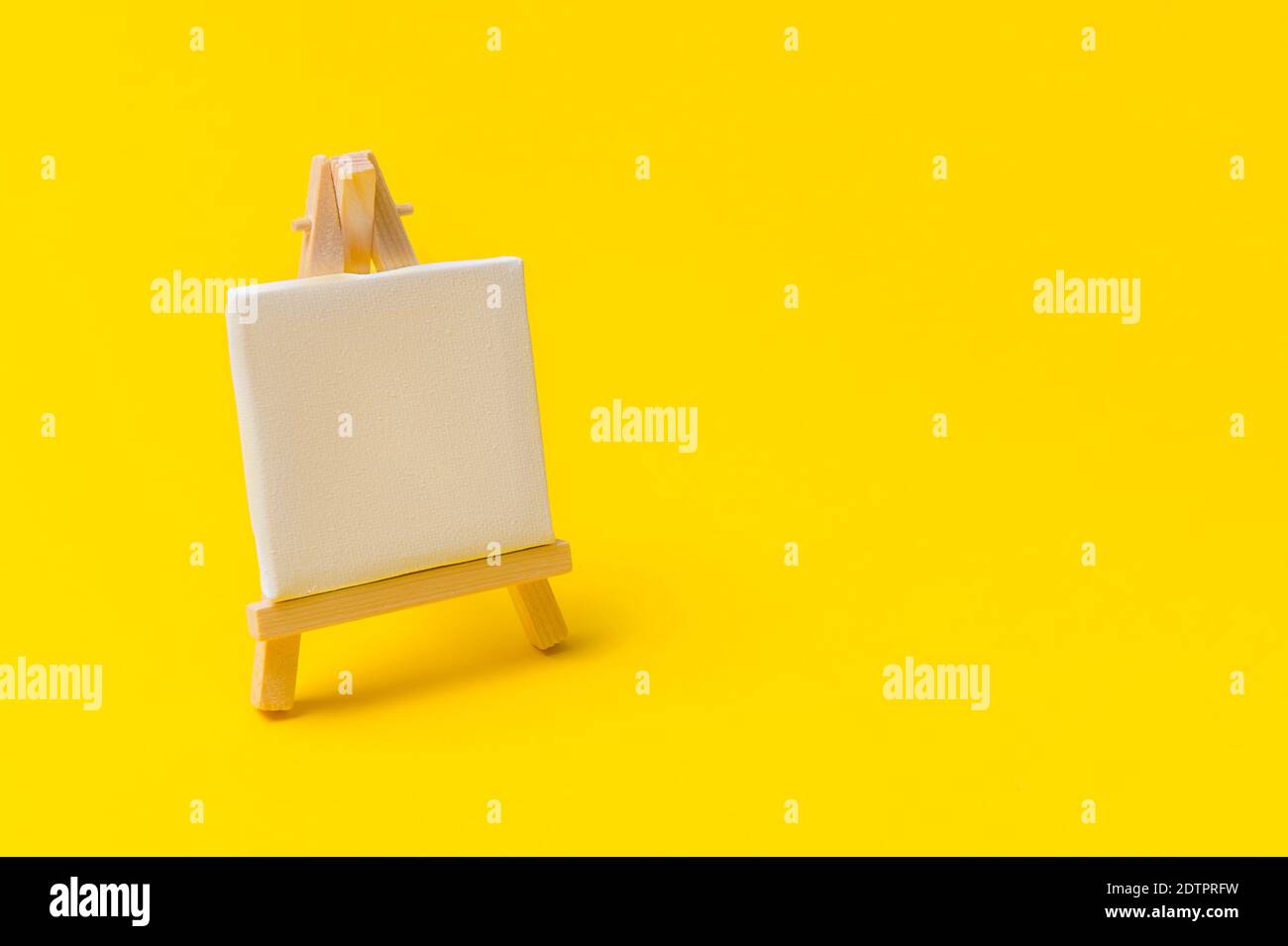 Wooden molbert with a paper attached to it isolated on a yellow ...