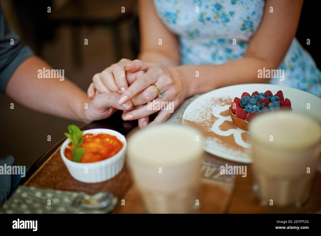 Couple holding hands in a cafe for a romantic lunch Stock Photo - Alamy
