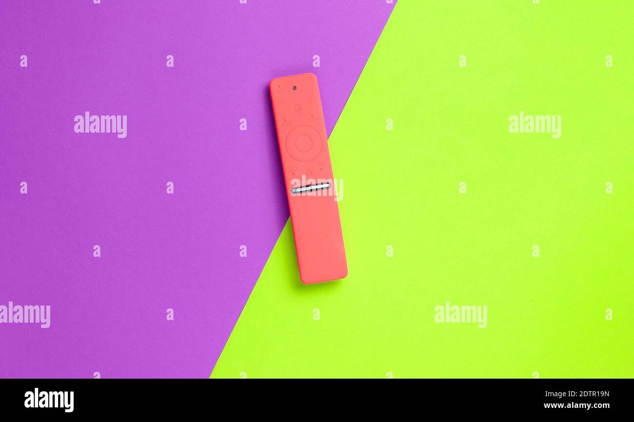 TV remote control in a red silicone case on a purple-green paper ...