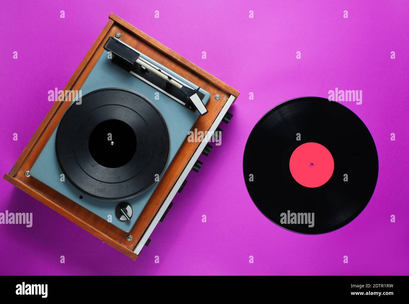 Retro 70s vinyl record player with a vinyl record on a purple ...