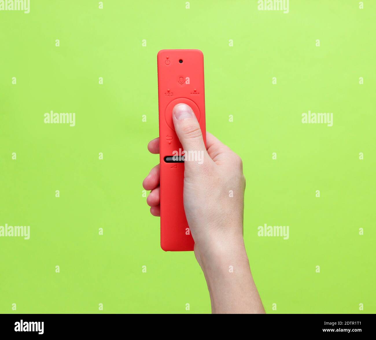 Female hand switches tv remote control on green background Stock Photo ...
