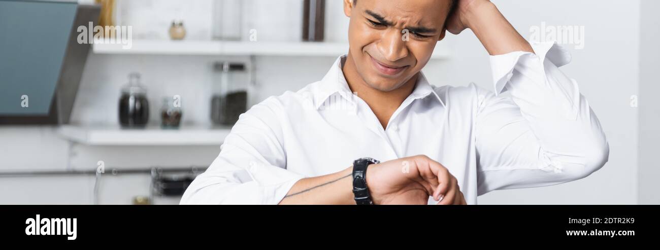 stressed african american man looking at watch, banner Stock Photo - Alamy