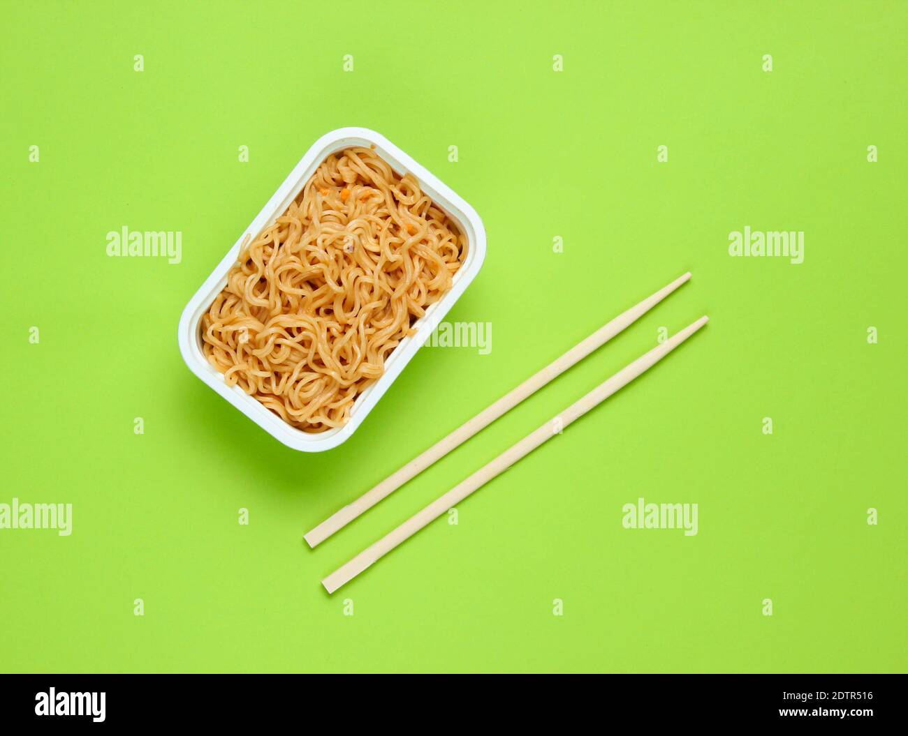 Instant noodles and chinese chopsticks on green background, minimalism ...