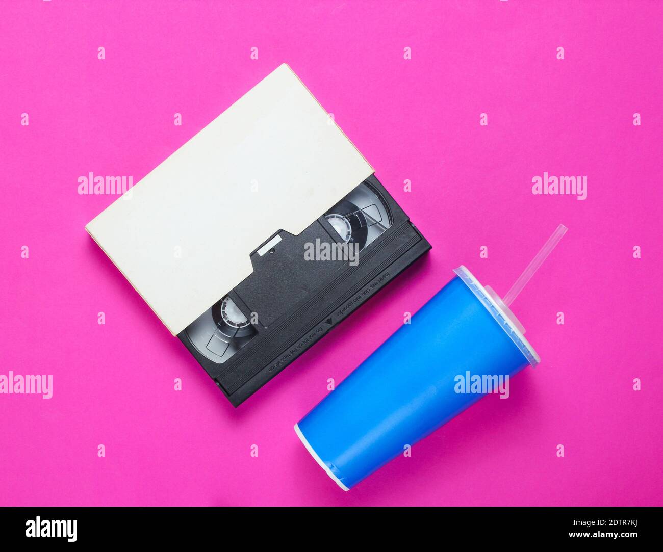 Paper cup with straw, video cassette on pink background. Pop culture ...