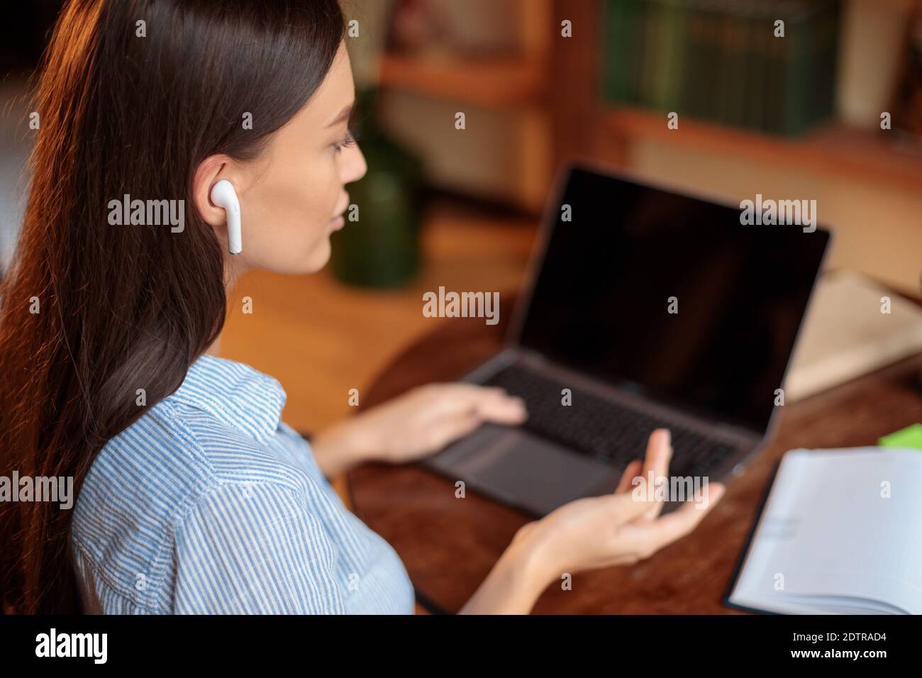 Lady using laptop with blank mockup screen, talking Stock Photo - Alamy