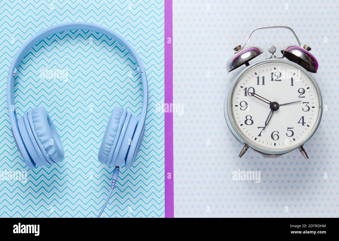 Music time concept. Retro alarm clock and headphones on creative ...