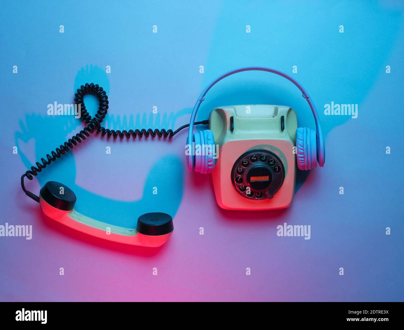 Vintage rotary phone with headphones. Retro wave, red blue neon light ...