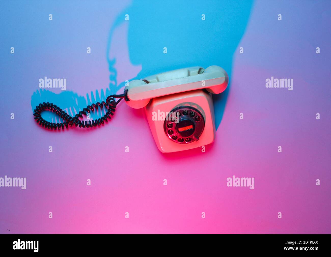 Vintage rotary phone. Retro wave, pink blue neon light, ultraviolet ...