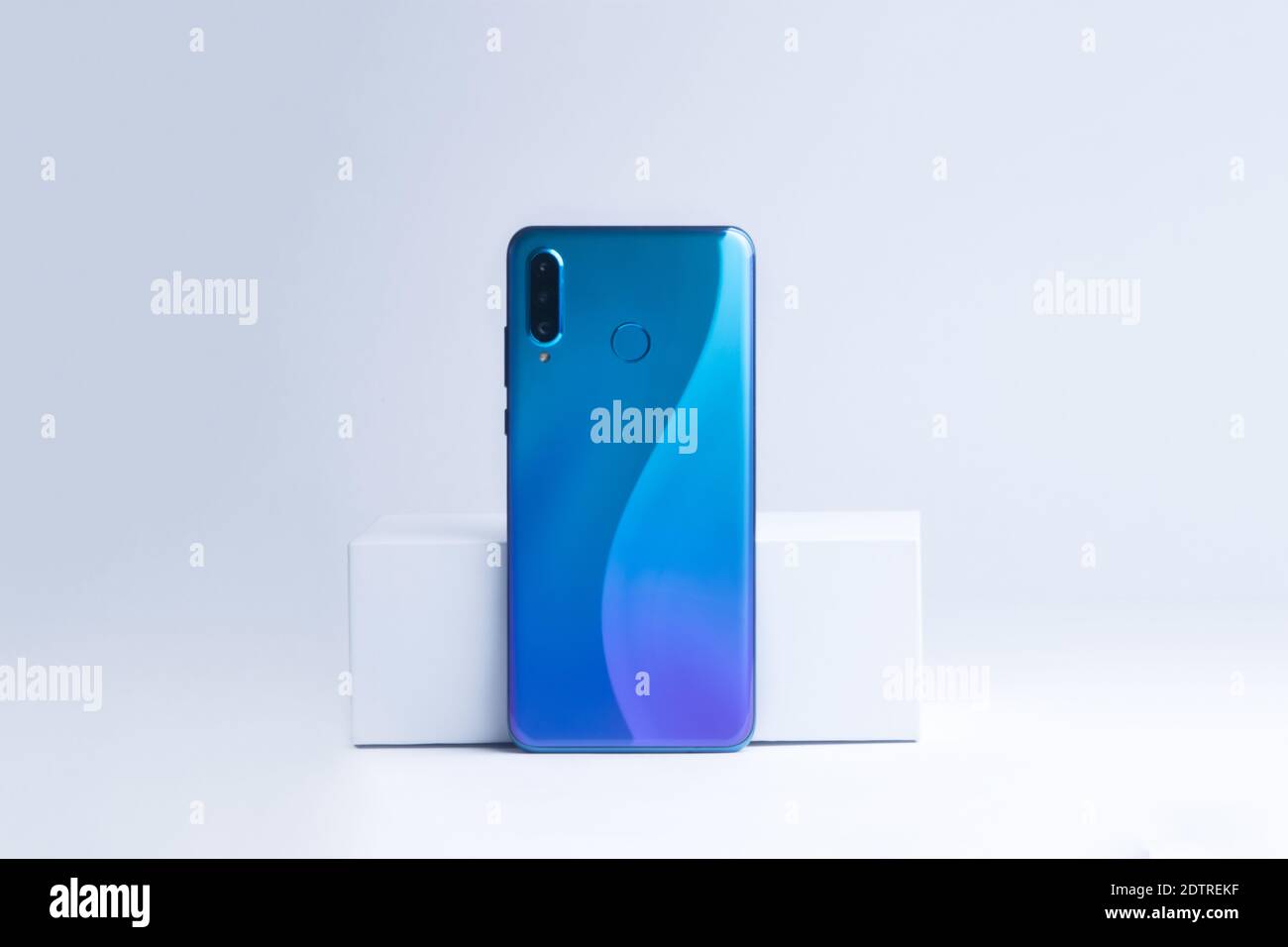 A closeup shot of a blue cell phone with camera and fingerprint reader ...