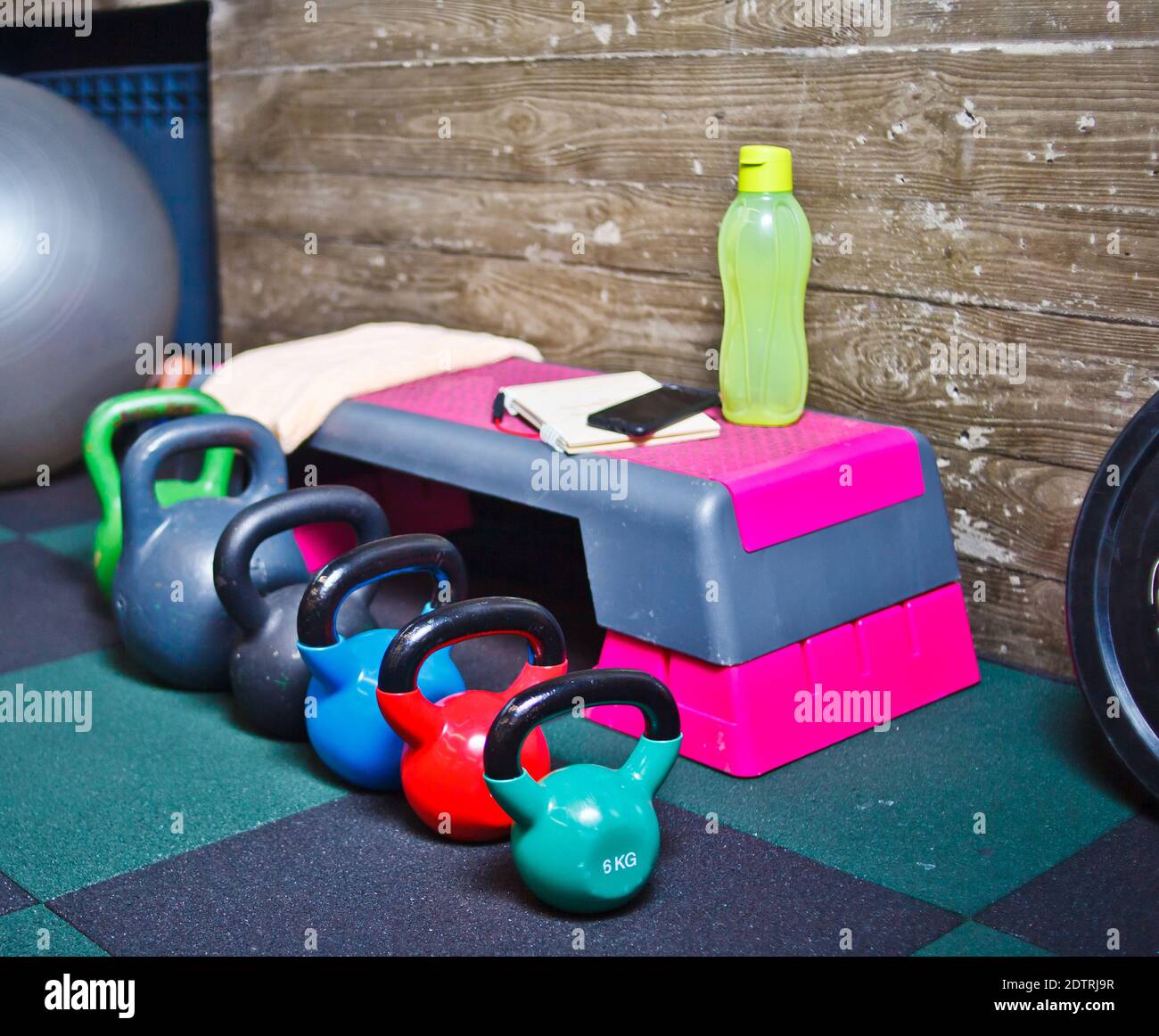 Colorful kettlebells set and other functional exercise equipment on the ...