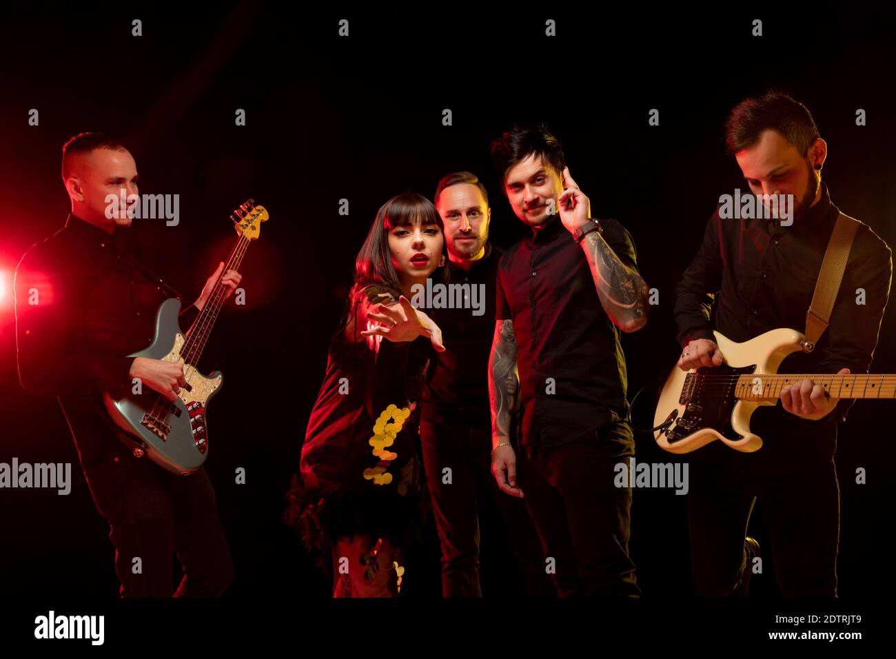 Stylish. Musician's band portrait isolated on dark studio background in ...