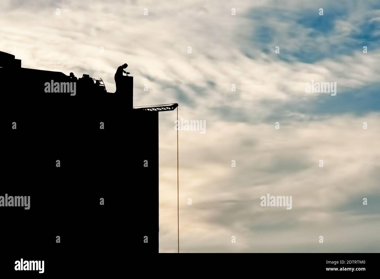 Man hanging on side of building hi-res stock photography and images - Alamy