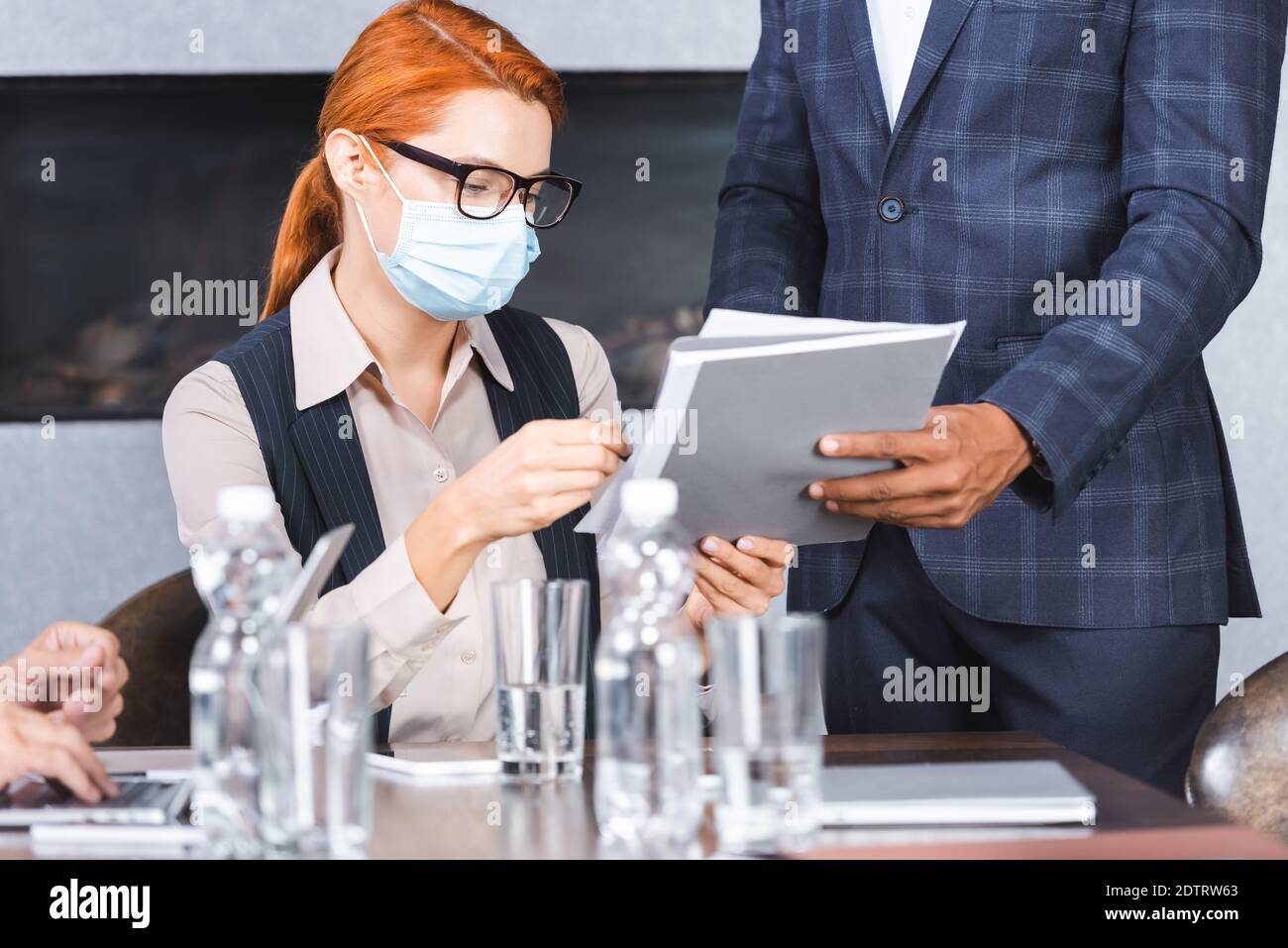 African american businessman showing paper folder to female executive ...