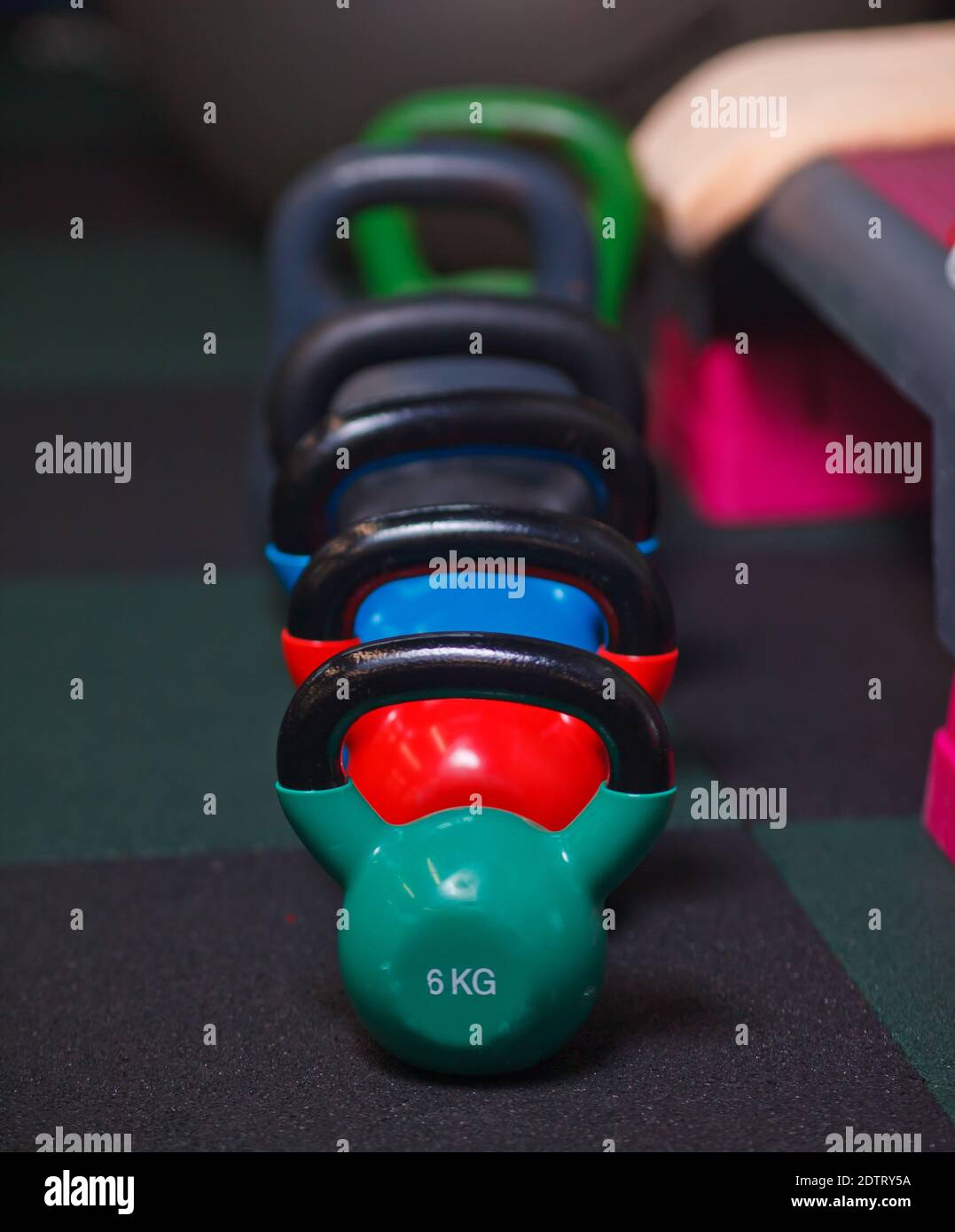 Colorful kettlebells set on the gym floor close up Stock Photo - Alamy