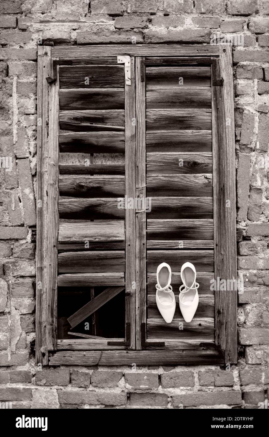 Women's wedding shoes hung on the window sill Stock Photo - Alamy