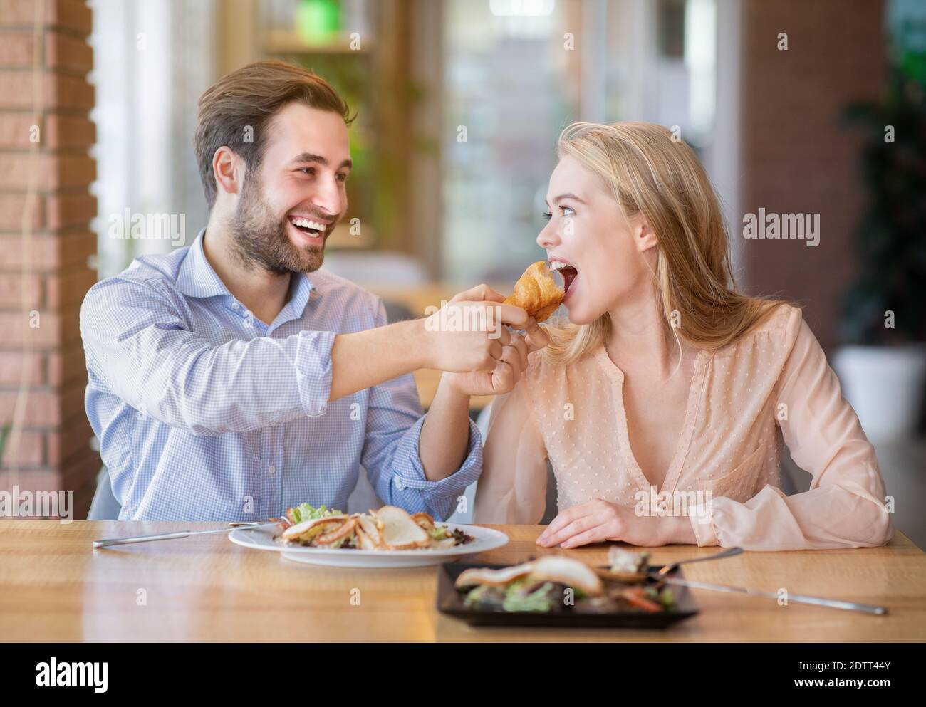 Romantic young woman feeding boyfriend hi-res stock photography and ...