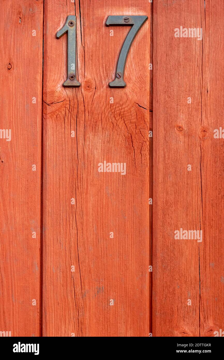 Rusty and red with weathered wood is the gate to house number 17 Stock ...