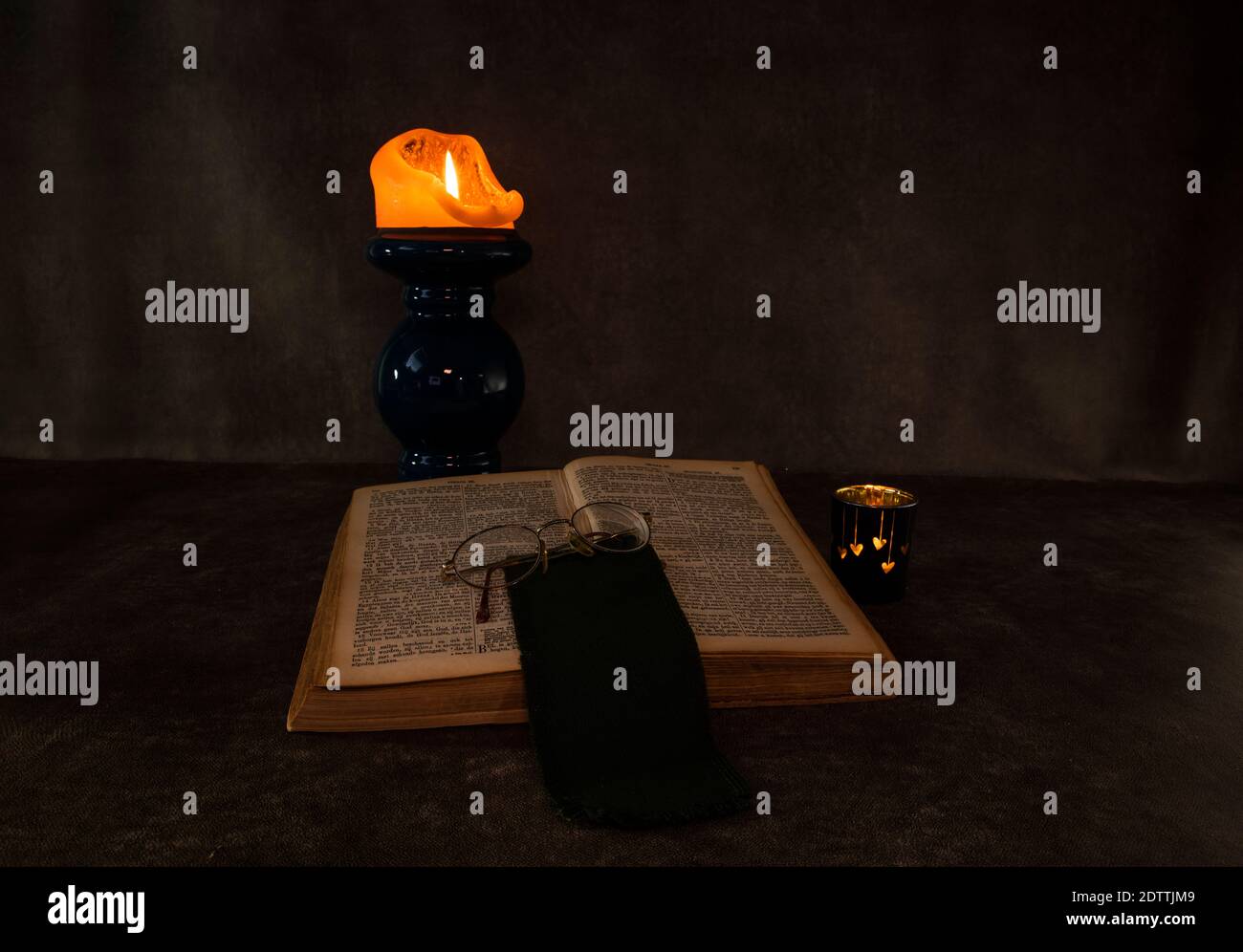Burning candle and an open old Christian book still life Stock Photo ...
