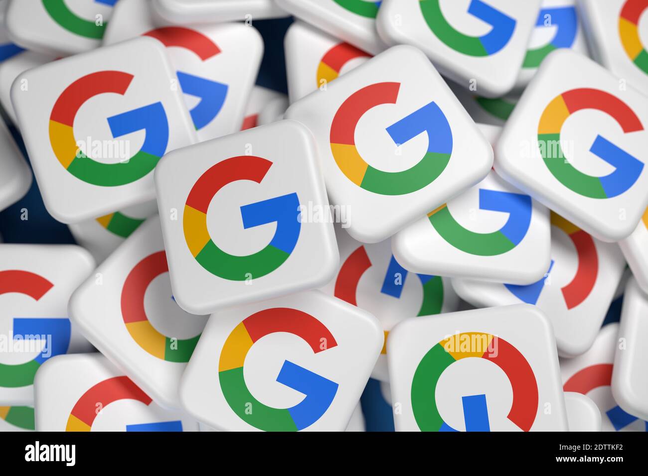 Logos of the company Google / Alphabet on a heap on a table. Full frame ...
