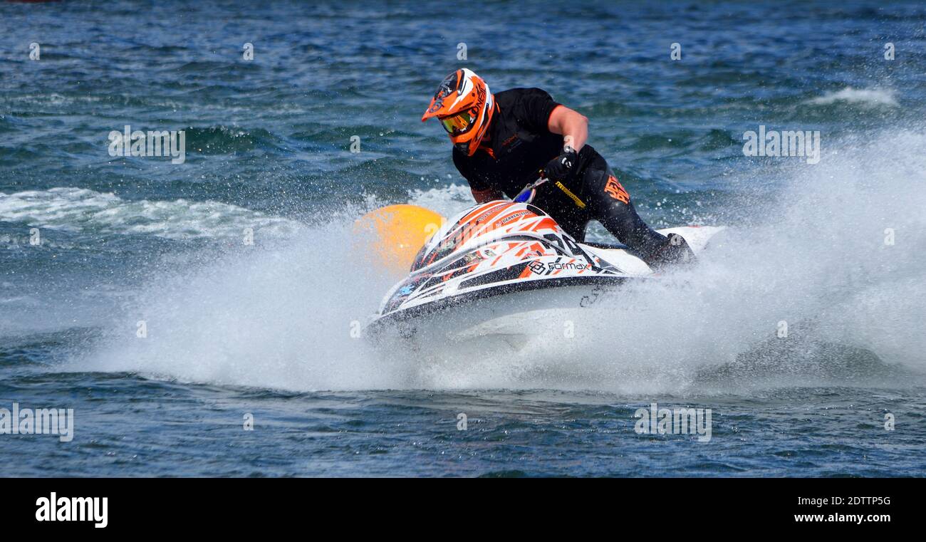 Close up of Jet Ski racer cornering at speed creating at lot of spray ...