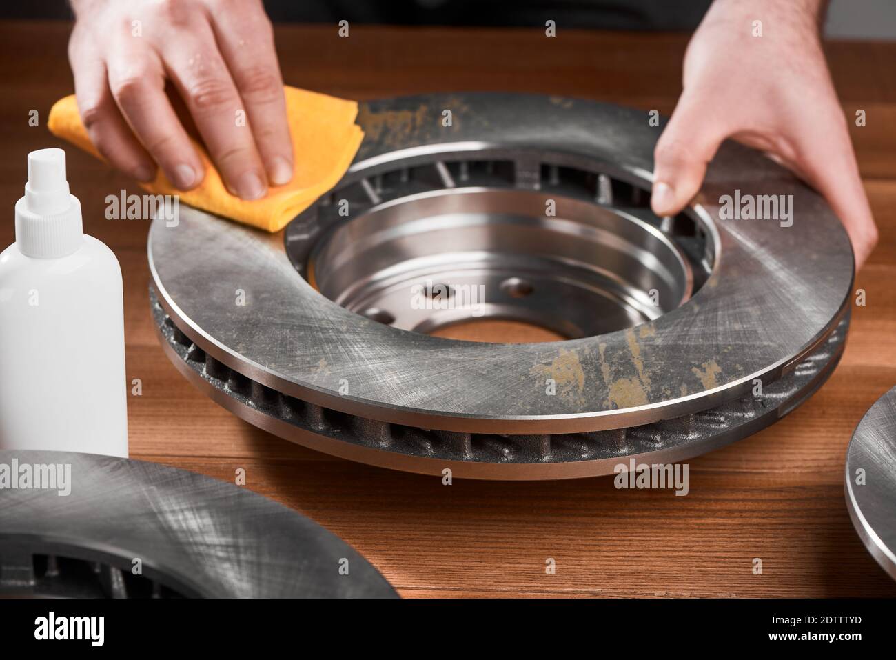 Man cleaning a brake rotor from rust, using a fabric cloth and anti ...