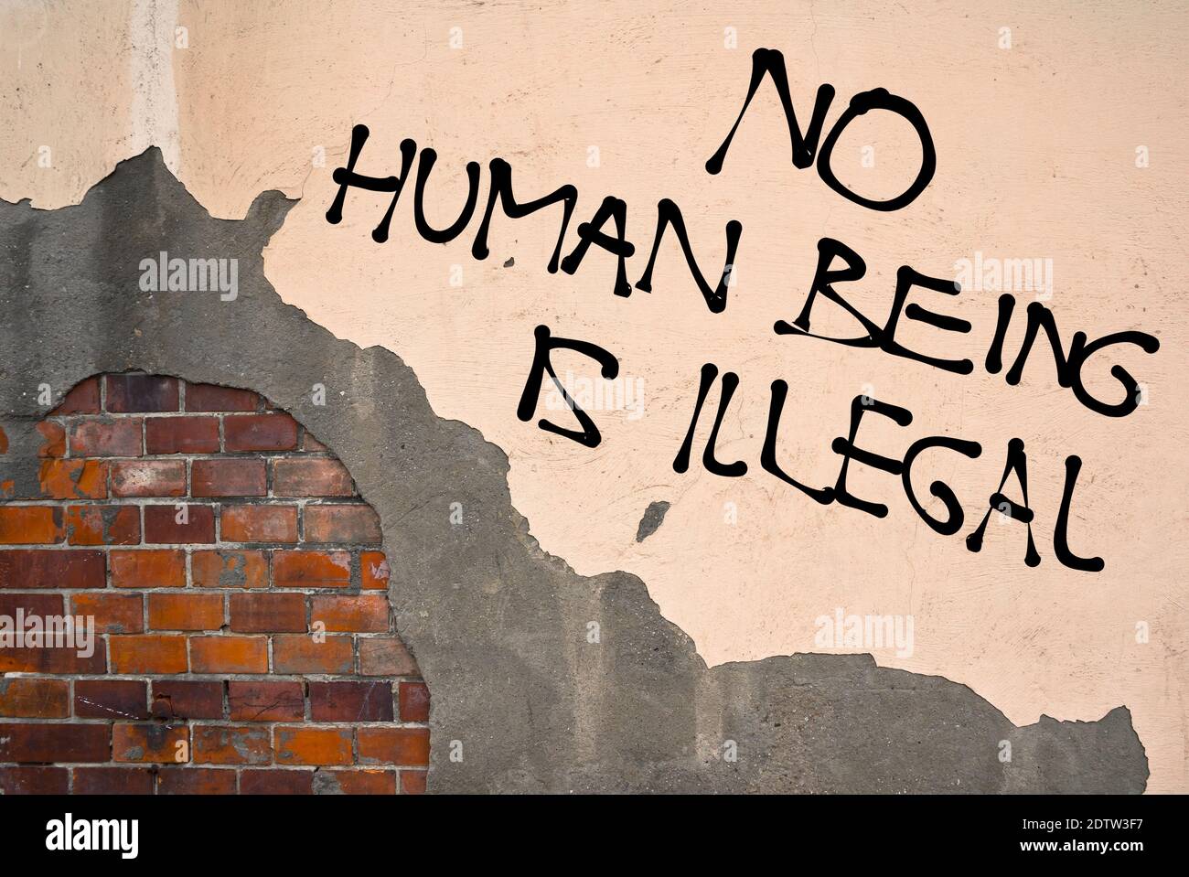 Handwritten graffiti No Human Being Is Illegal sprayed on the wall ...