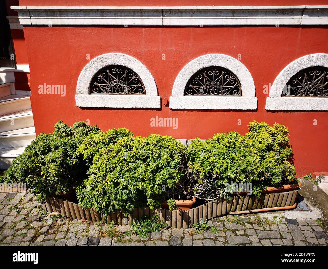 A high angle shot of a small garden by a red building on a street Stock ...