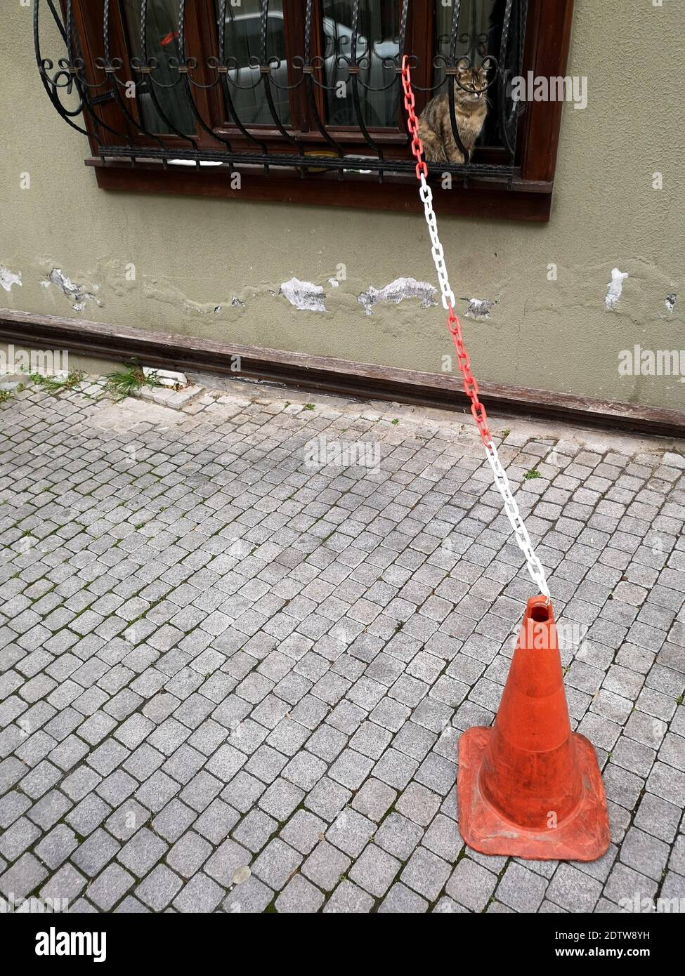 A vertical high angle shot of an orange traffic cone connected to a ...