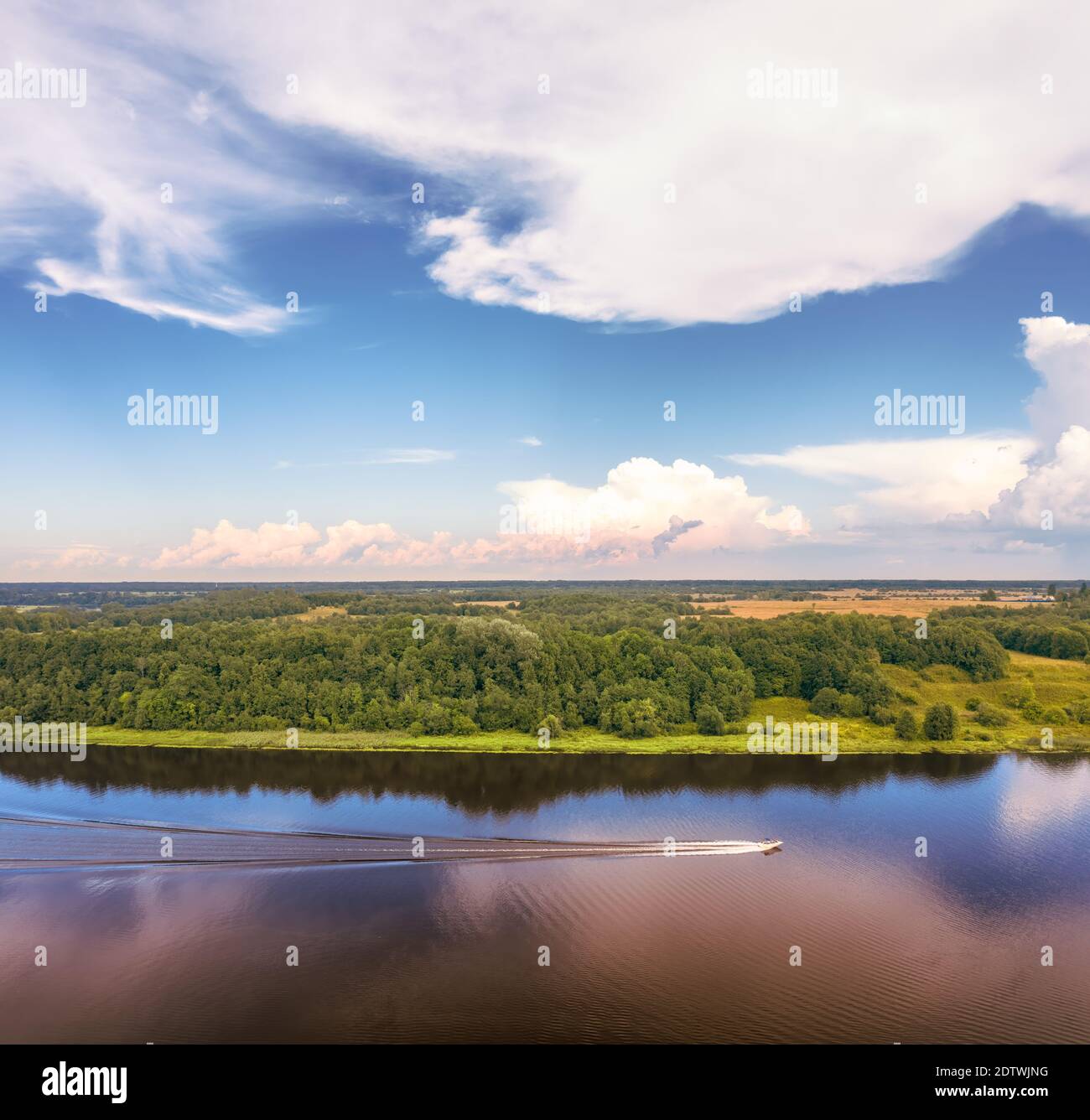 Aerial rural landscape with river, motor boat, forest and fields to the ...