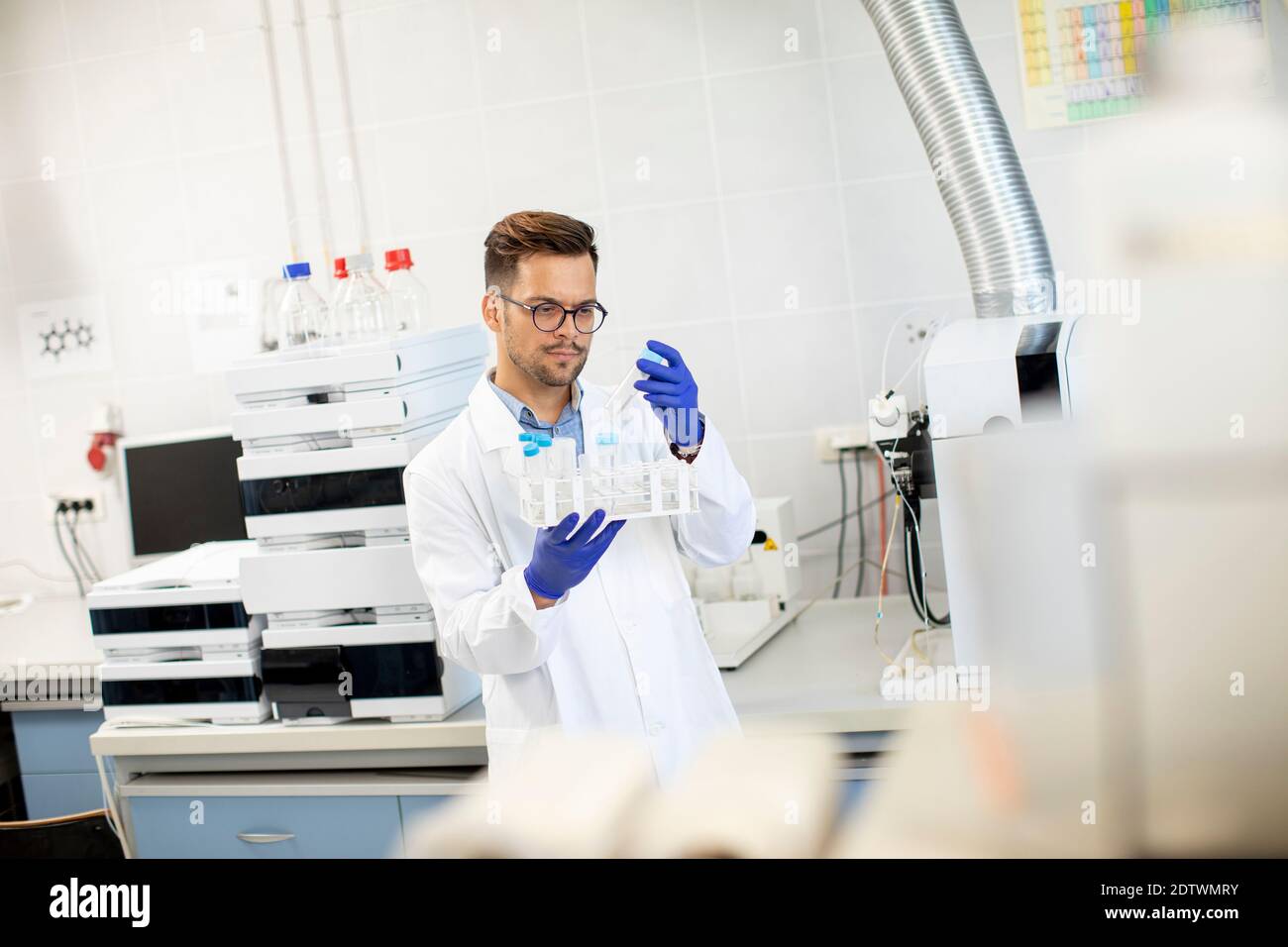 Handsome young researcher workin with chemical samples in laboratory ...