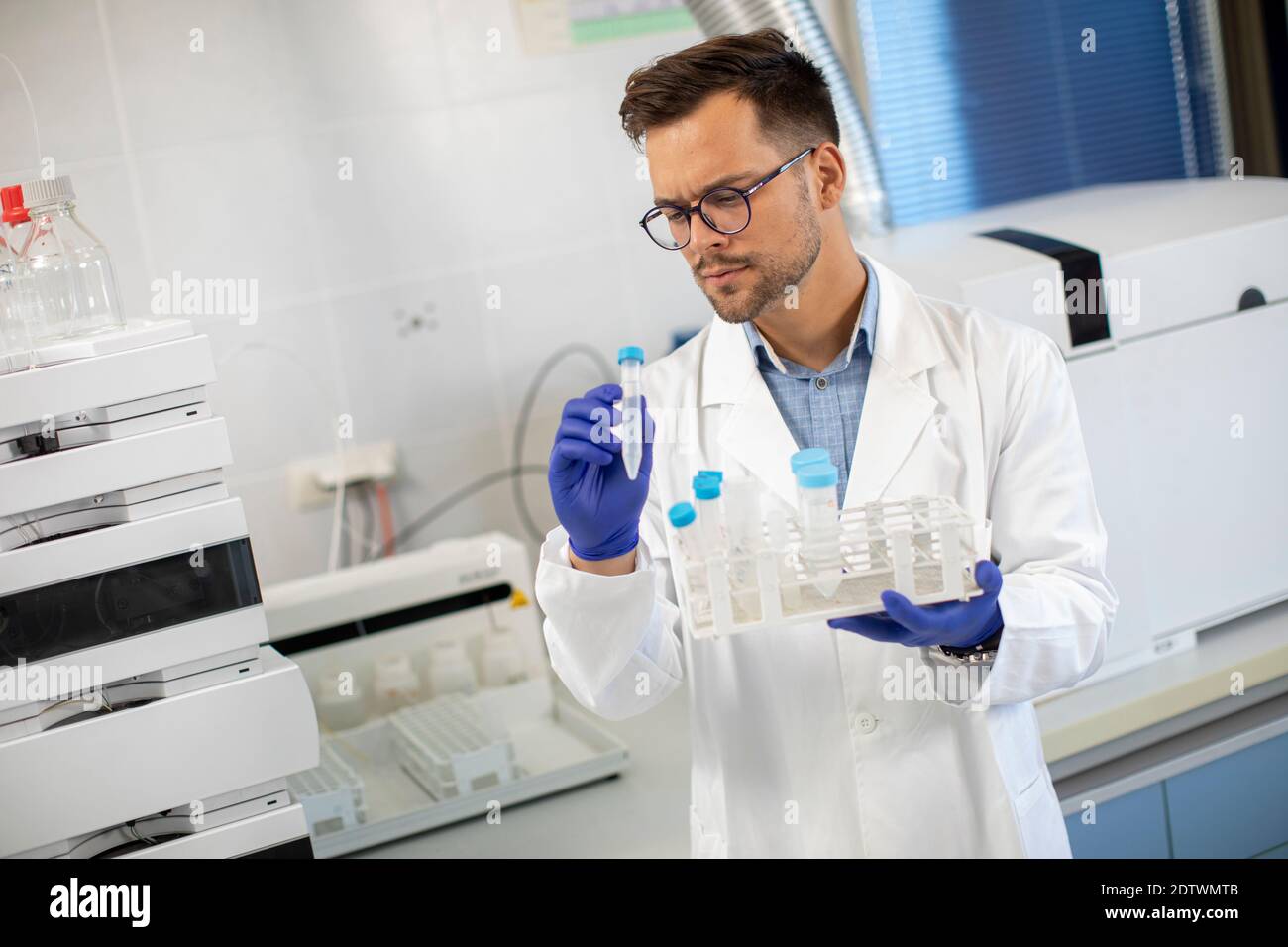 Handsome young researcher workin with chemical samples in laboratory ...