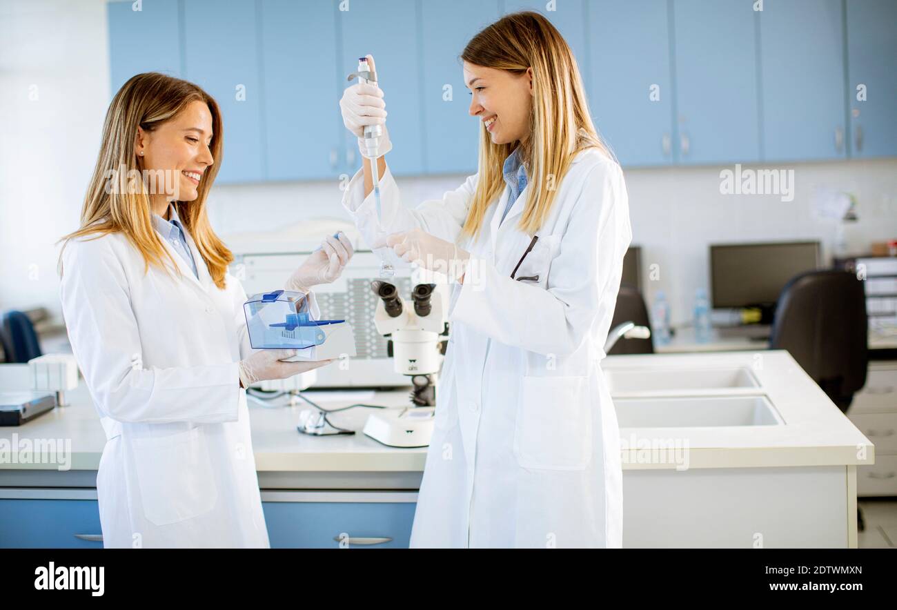 Cute female researchers in white lab coat working in the laboratory ...