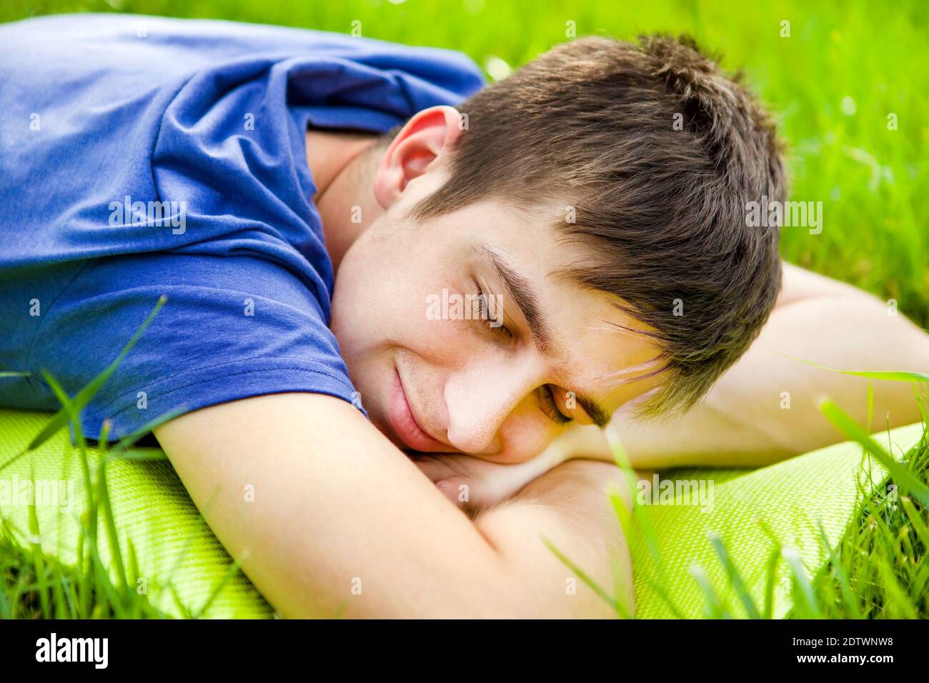 Young Man rest on the Grass of the Summer Meadow Stock Photo - Alamy