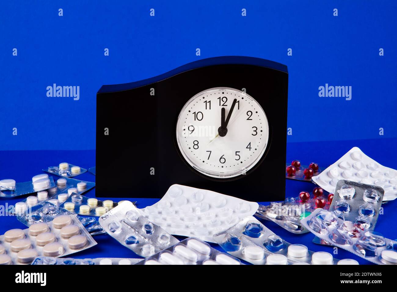 Clock with a Pills on the Blue Paper Background Stock Photo - Alamy