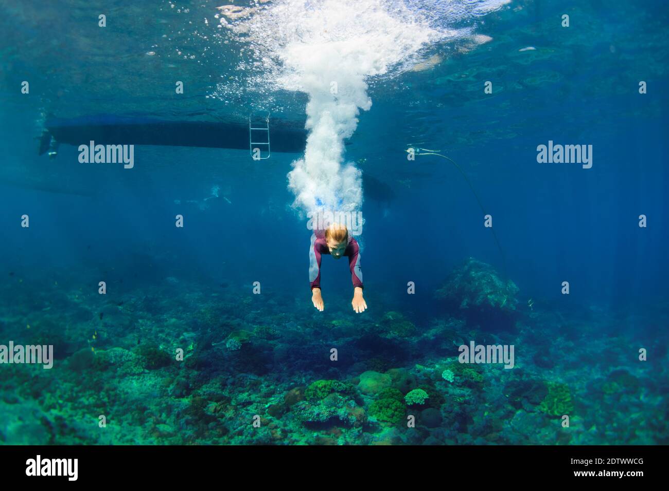 Active teenage man jump and dive underwater in tropical coral reef pool ...