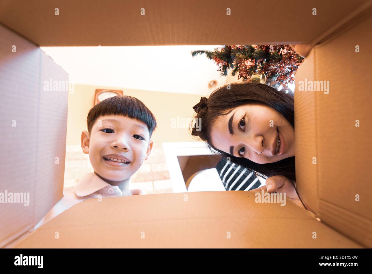 The surprised child and mom unpacking, opening the carton box and ...