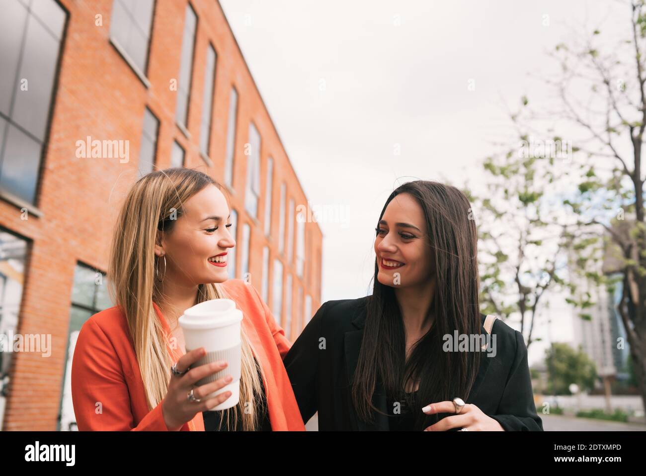 Two young friends walking together outdoors Stock Photo - Alamy