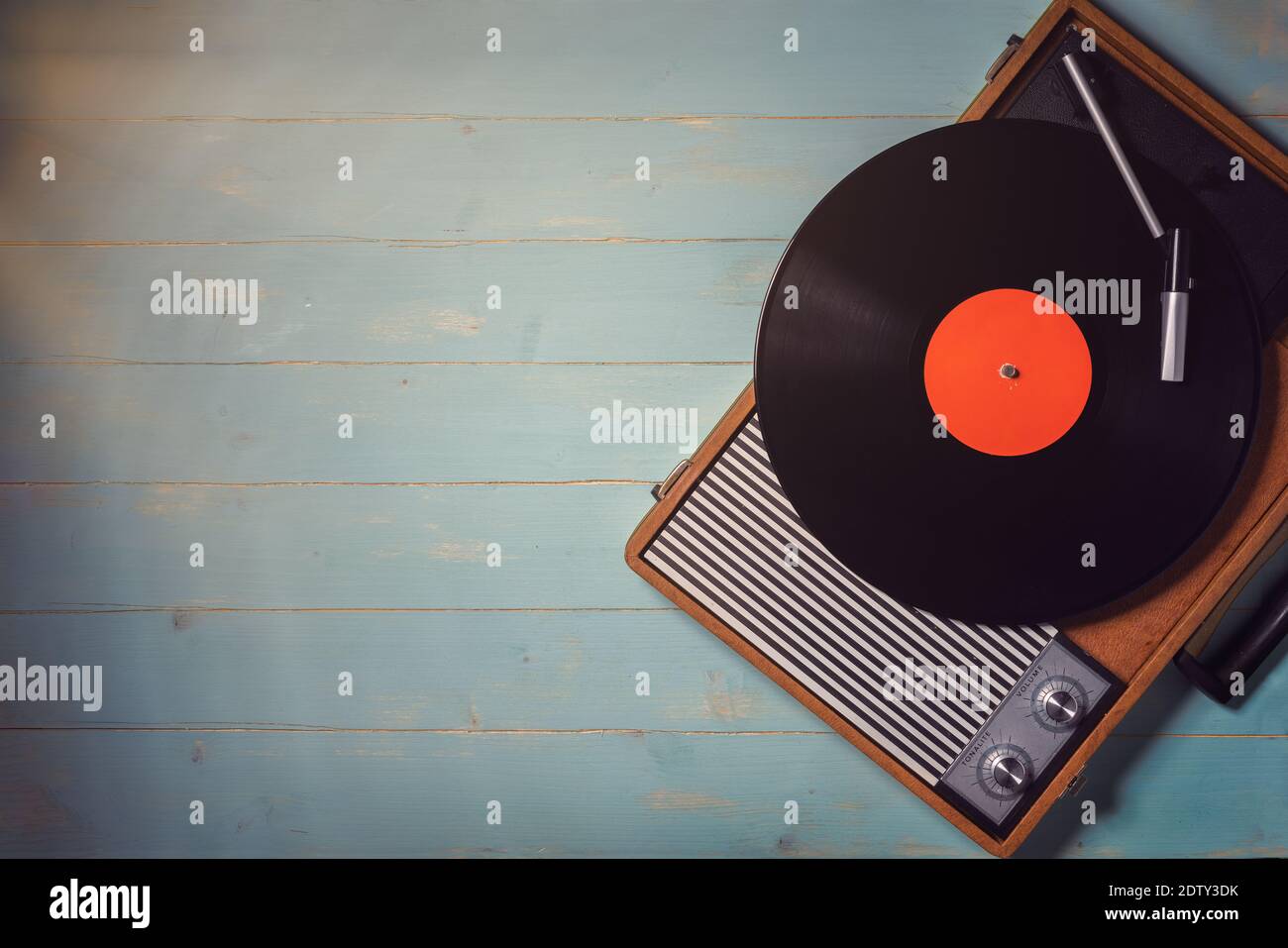 Old record player from the 70s with a vinyl record on green wooden ...