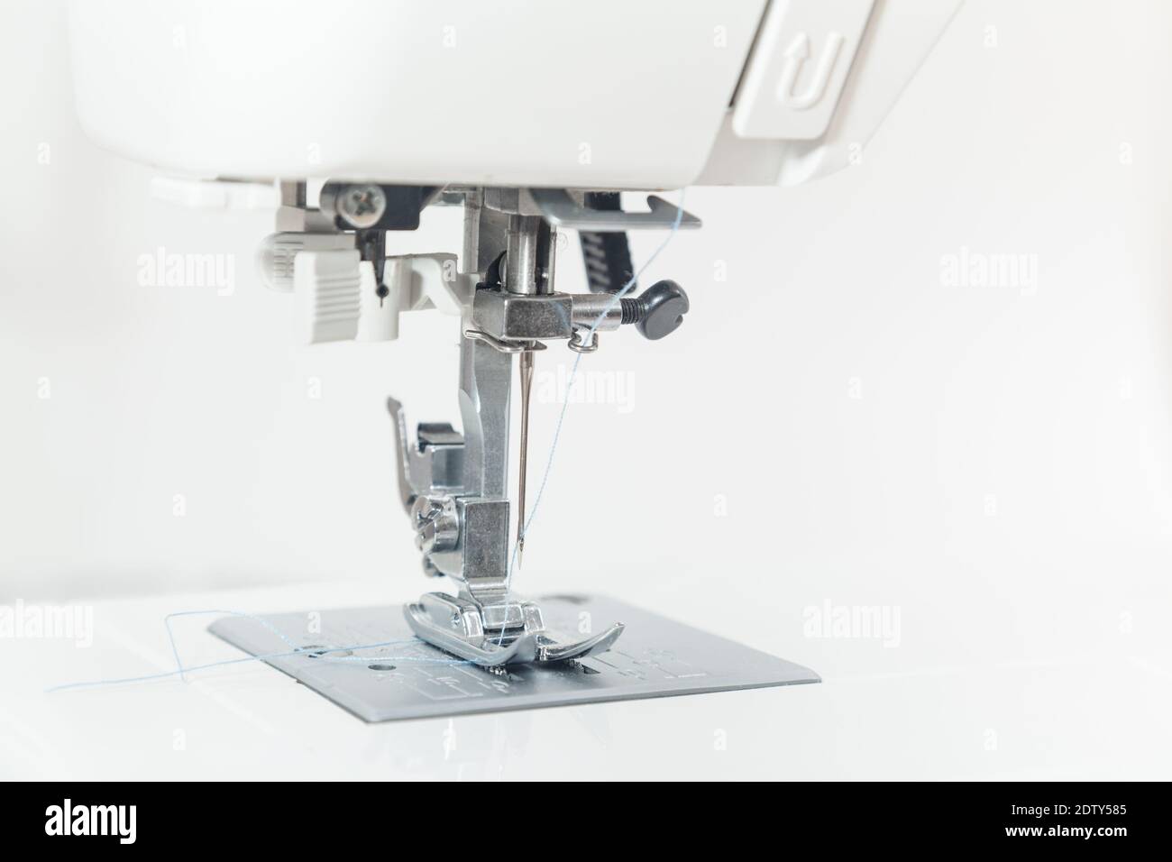 Closeup of sewing machine needle against white background Stock Photo ...