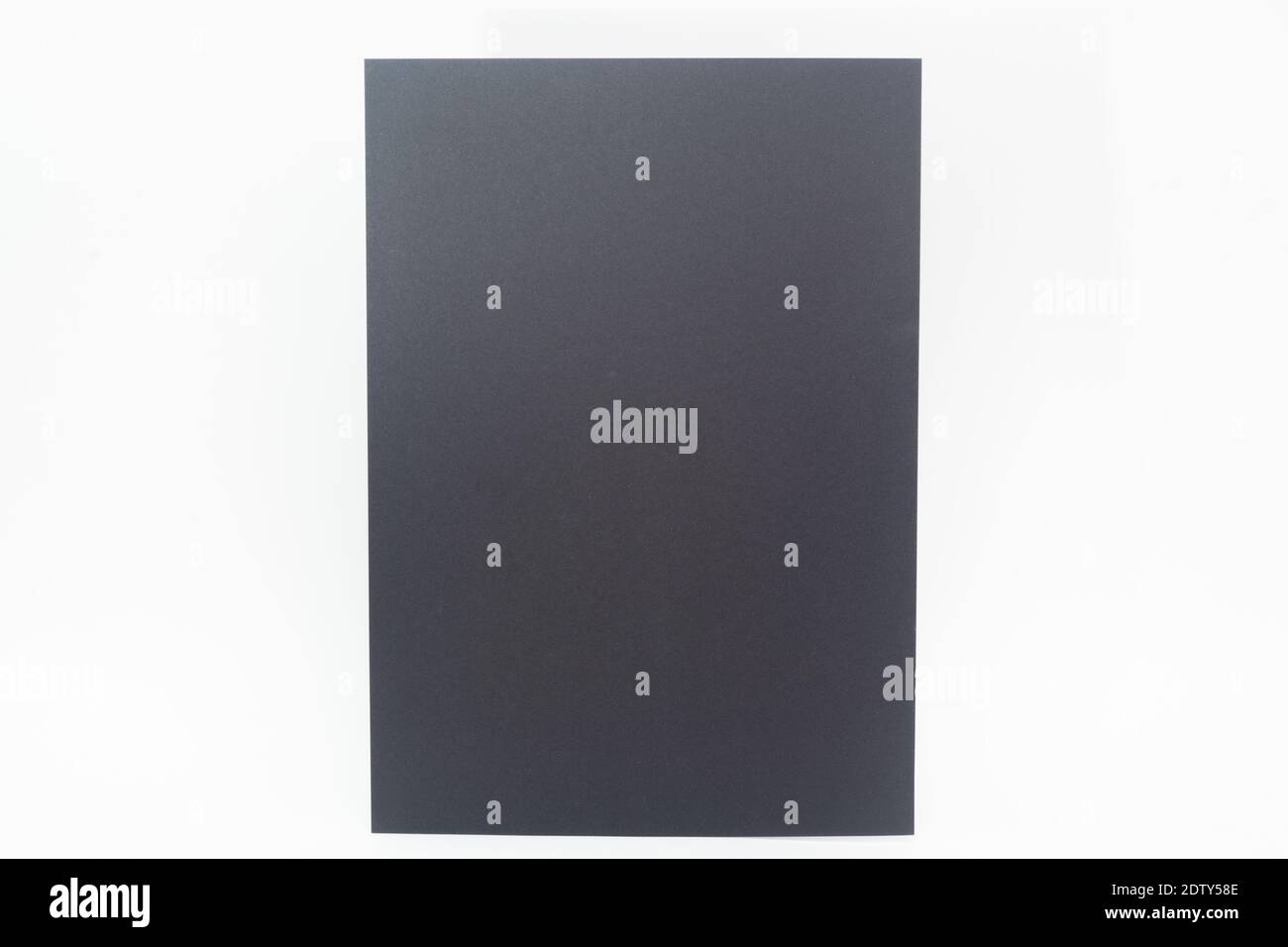 Vertical black paper sheet against white background Stock Photo - Alamy