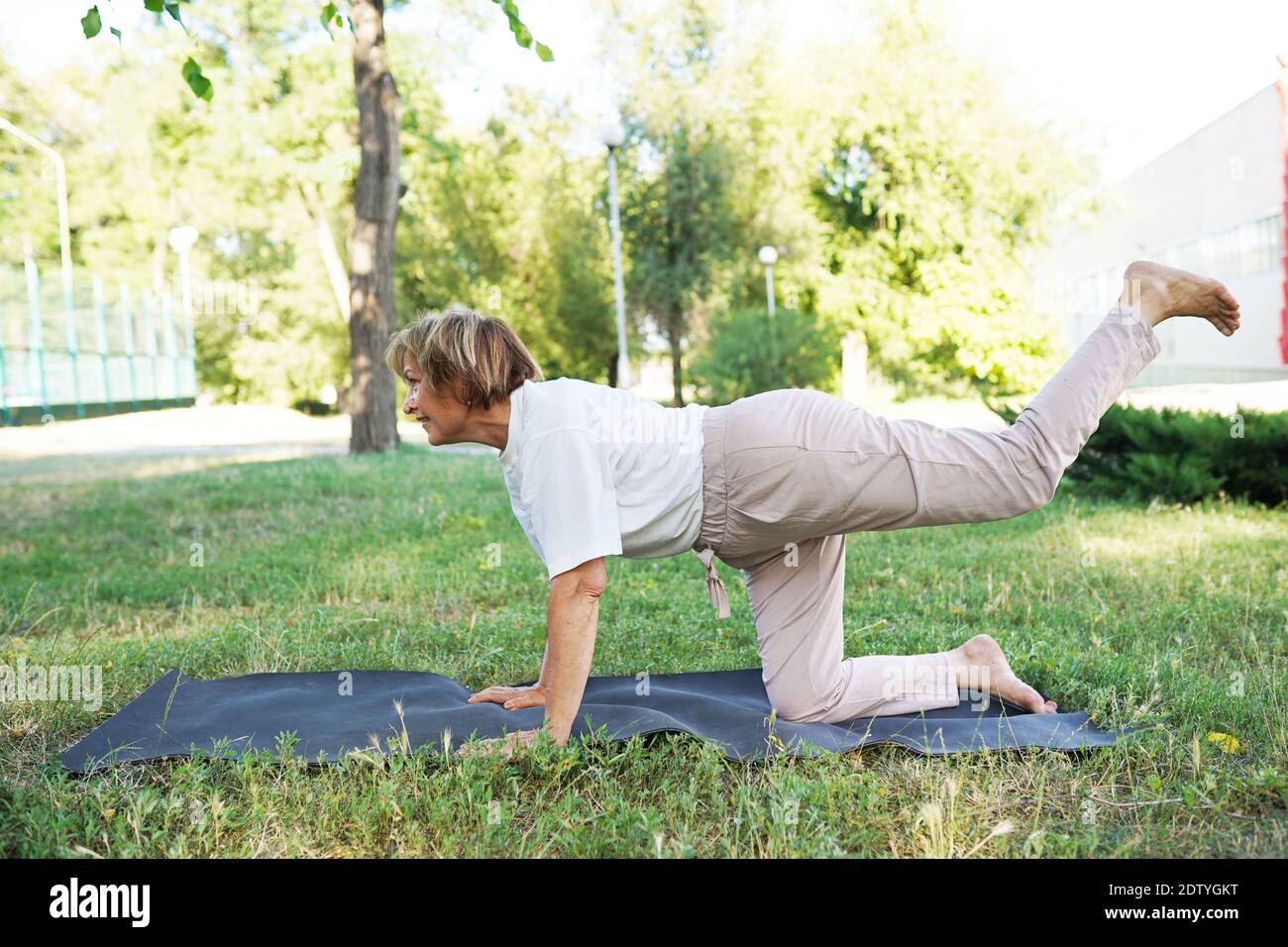 Young woman doing sports in a green park. A natural and impressive ...