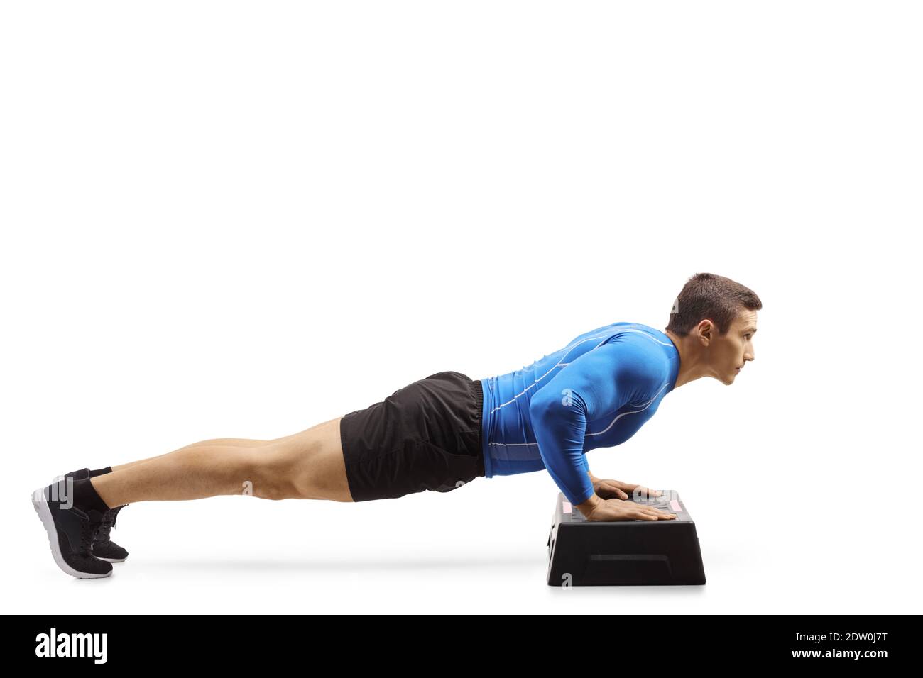 Strong young man exercising push-ups on a step aerobic platform ...
