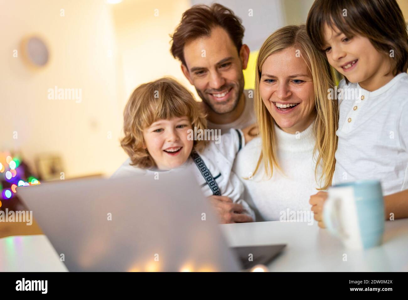 Happy young family using laptop at home Stock Photo - Alamy