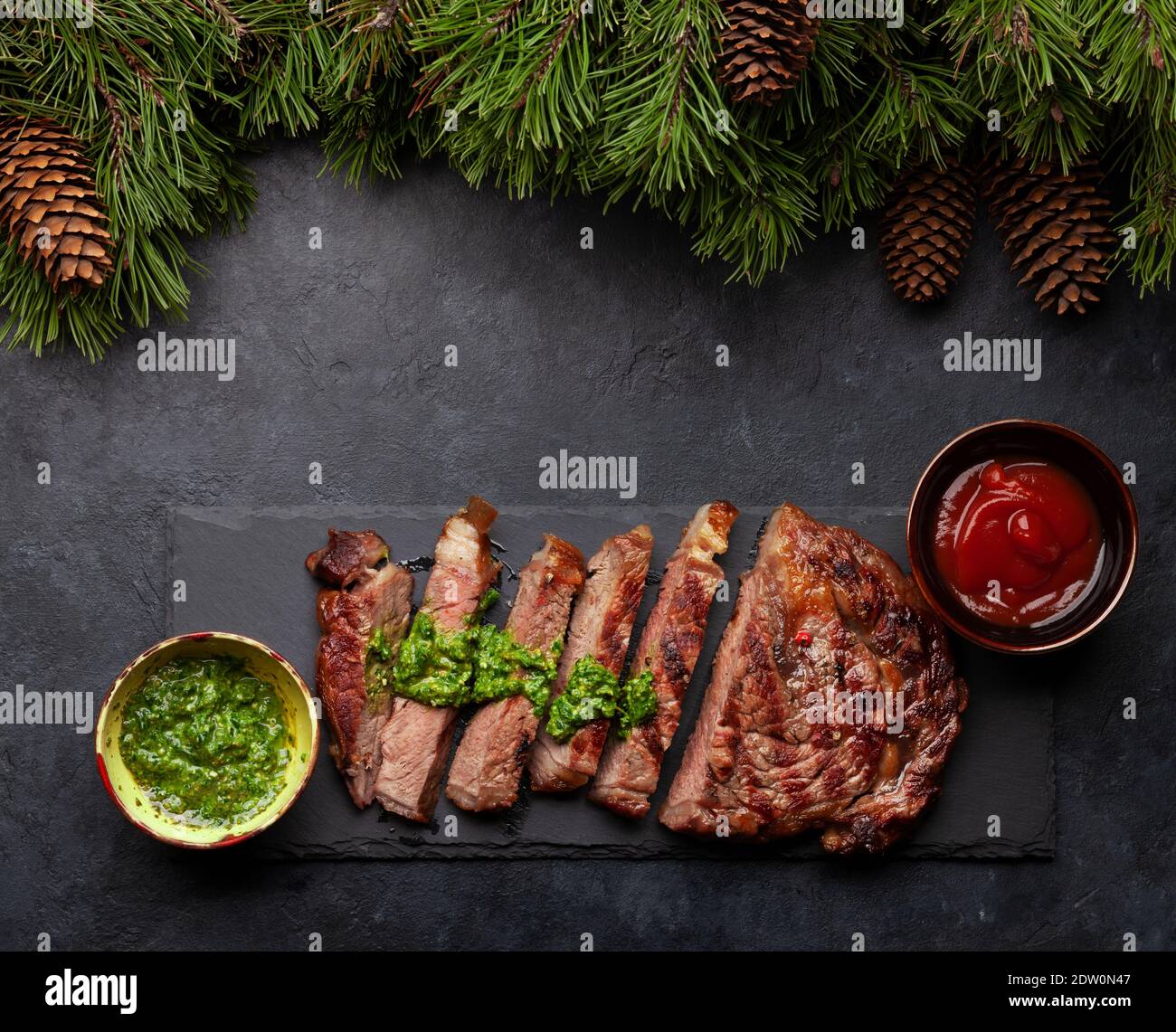 Grilled beef steak with sauces and christmas fir tree on stone ...
