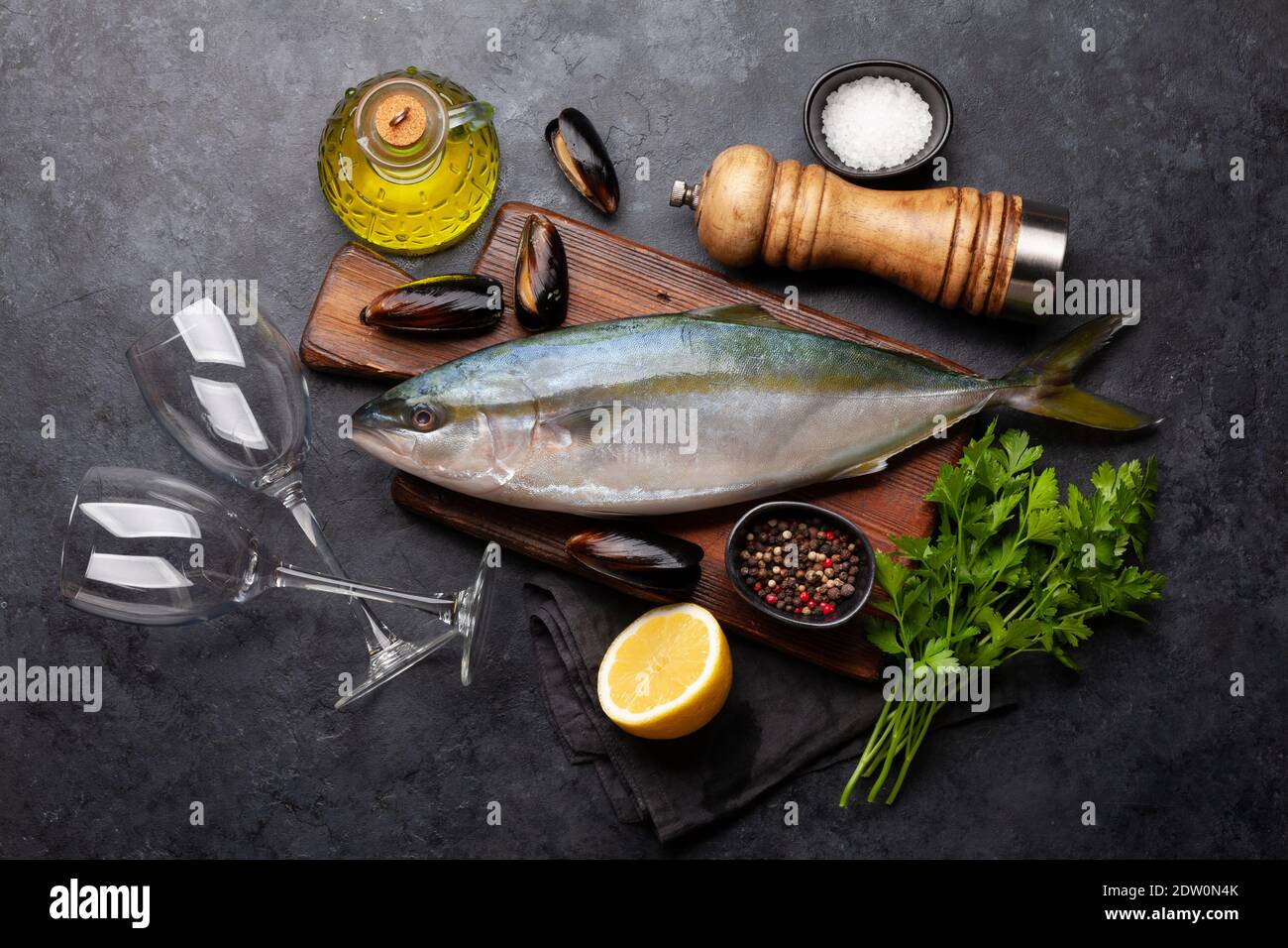Raw fish cooking. Seafood and ingredients for dinner on stone table ...