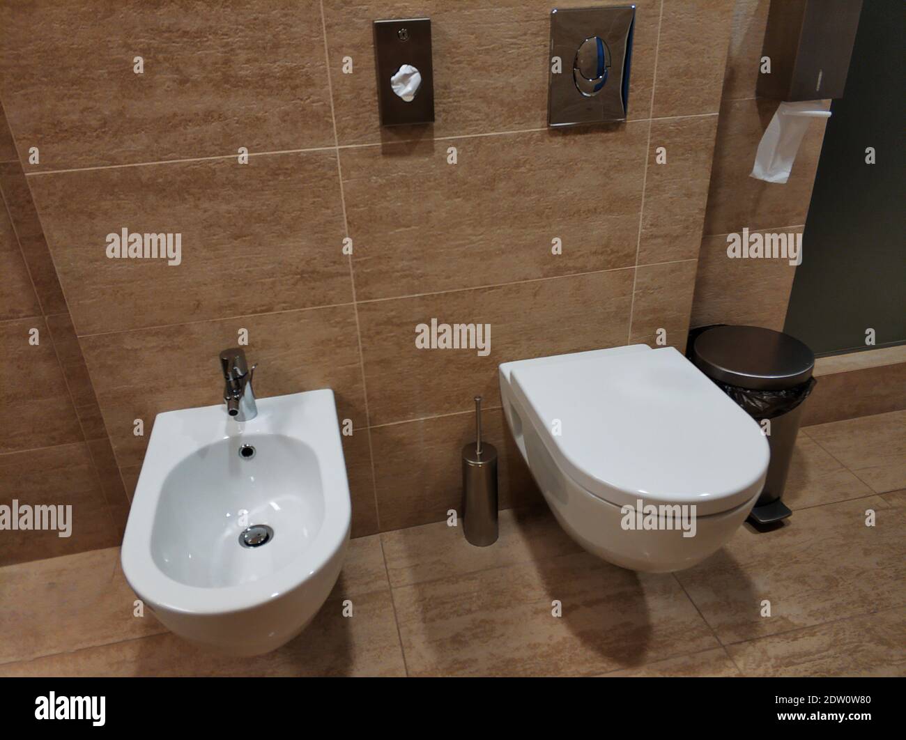 Stylish dressing room with bidet. Beige tiles Stock Photo - Alamy