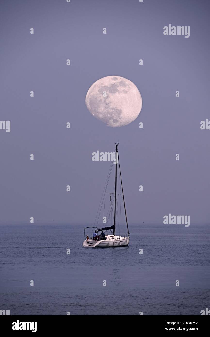 Sailboat sailing in the sea with the moon, full moon, dusk, cold tomes ...