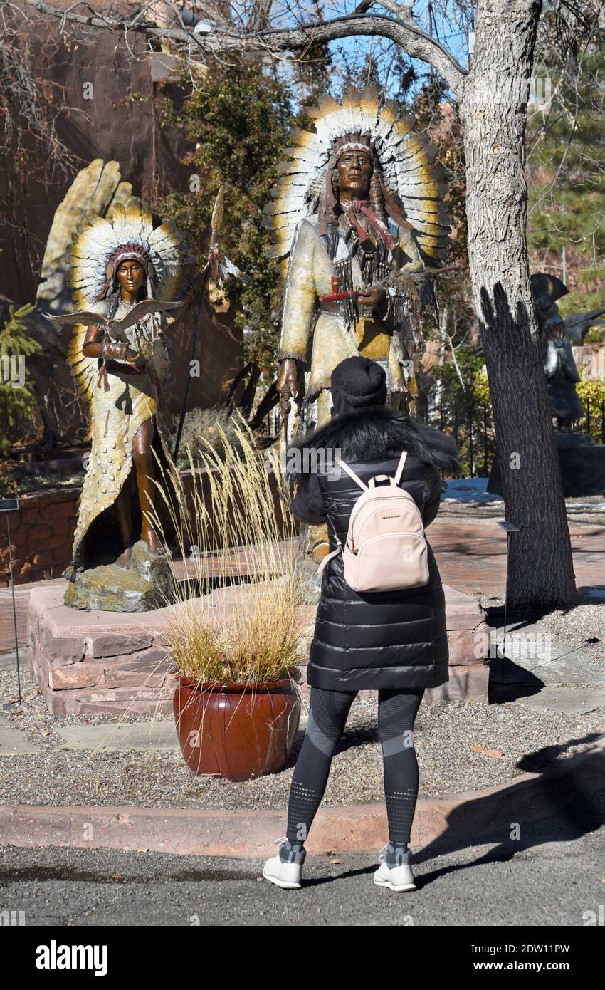 A tourist photographs a bronze sculpture by Ed Natiya of the famous ...