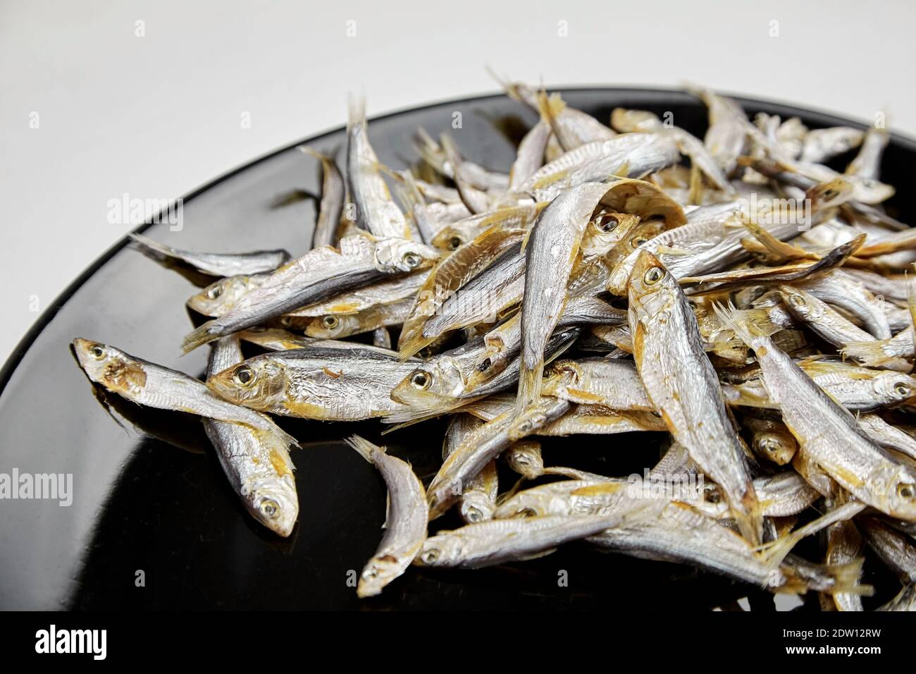 Dried salted small fish on black plate background. Beer snack Stock ...