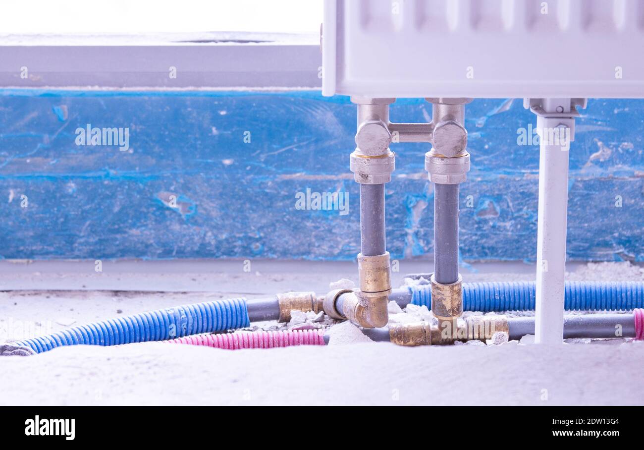 white metal radiator connected by plastic pipes at the bottom Stock ...